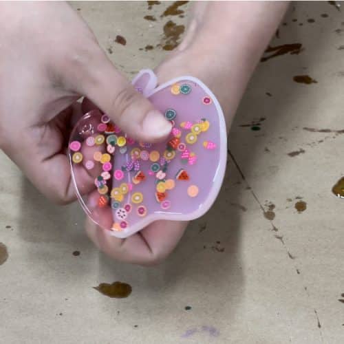 Apple-custom-magnet-with-fruit-confetti-being-demolded - Resin Crafts Blog