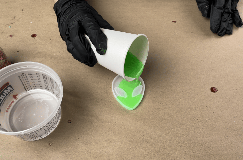 Resin-mixed-with-dye-and-glow-in-the-dark-powder-poured-into-alien-mold ...