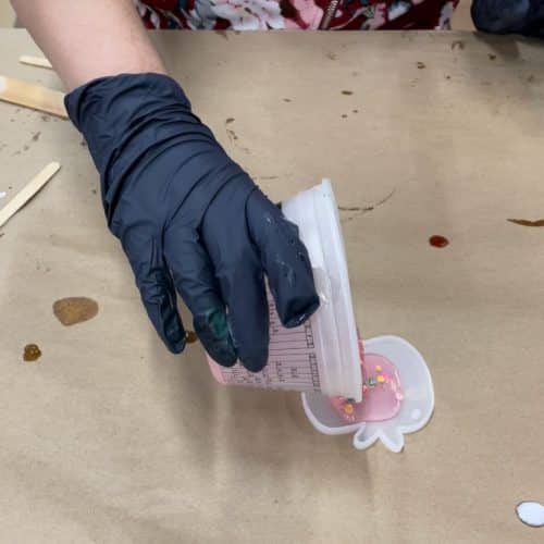 Translucent-red-resin-and-fruit-shaped-additives-poured-into-apple-mold ...